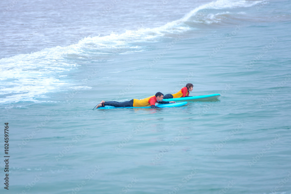Family of surfers learning to surf in the Atlantic ocean. First surfing ...