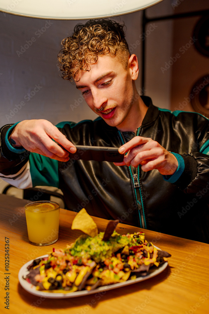 Young white guy taking photos with his smart phone of a plate of ...