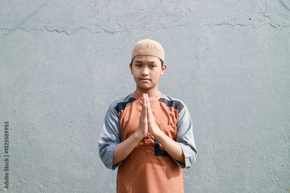 Young Asian Muslim man in Arabic costume standing with gesturing Eid ...