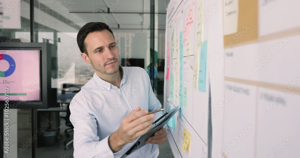Close up serious Hispanic man stand near wall with post-it memo ...