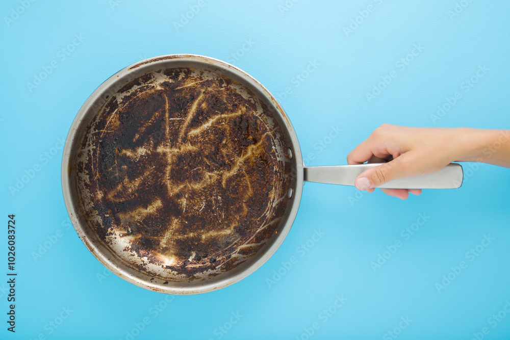 Young adult woman hand holding and showing dirty oily stainless frying ...