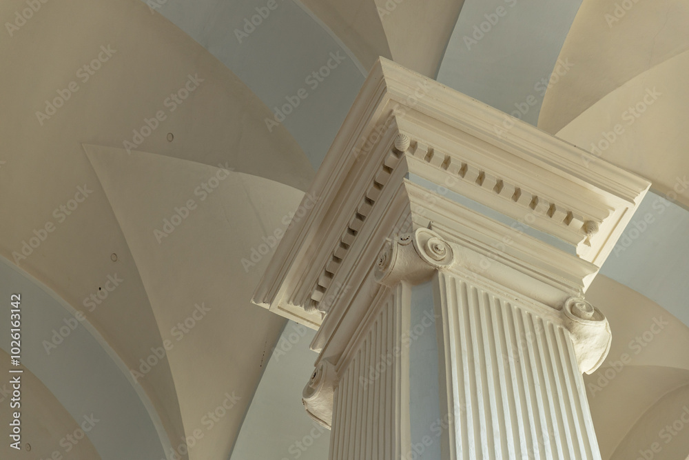 Close-up of a white pillar in a building with an arched ceiling. The ...