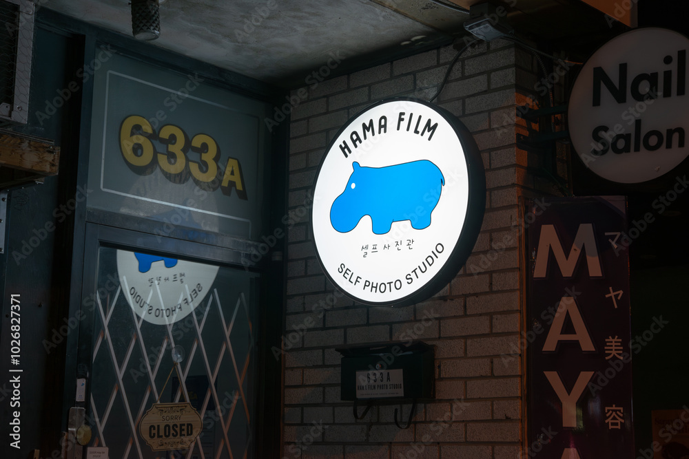 exterior illuminated sign of Hama Film, a photography studio, located ...