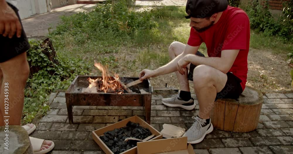 Friends getting ready to grill in the backyard. The video shows them ...