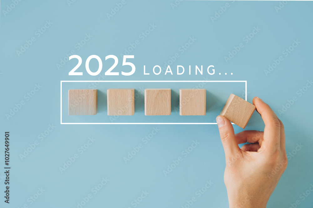 2025 New Year Loading. Female hand moving wooden blocks with Loading ...