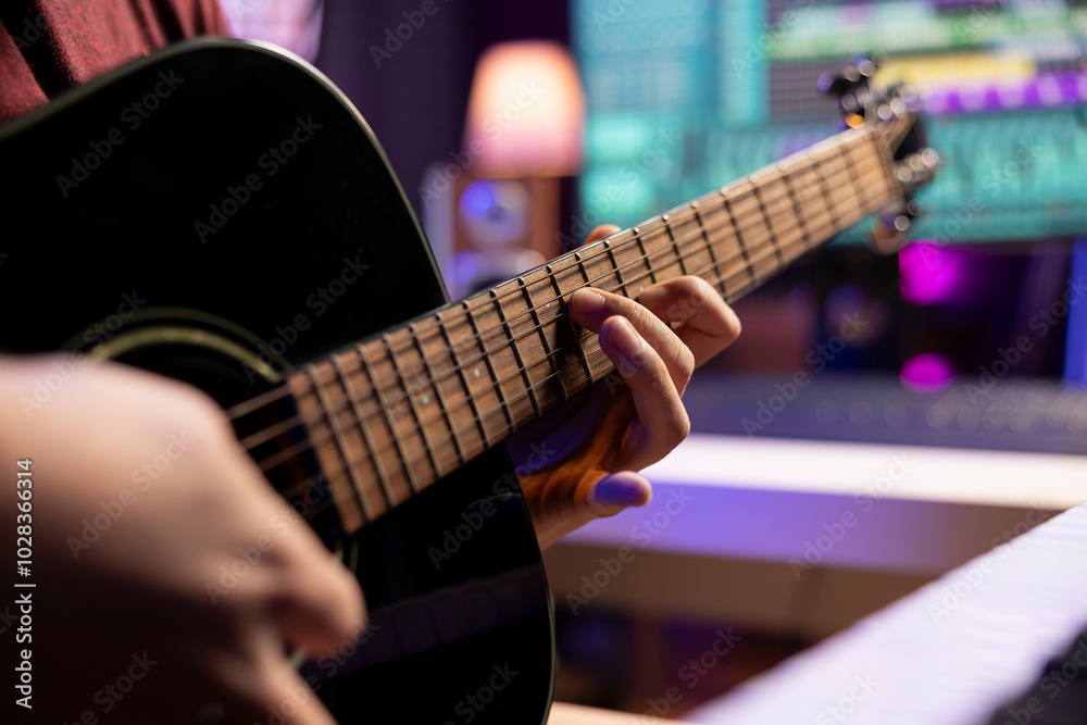 Music producer playing a new song on his acoustic guitar before ...