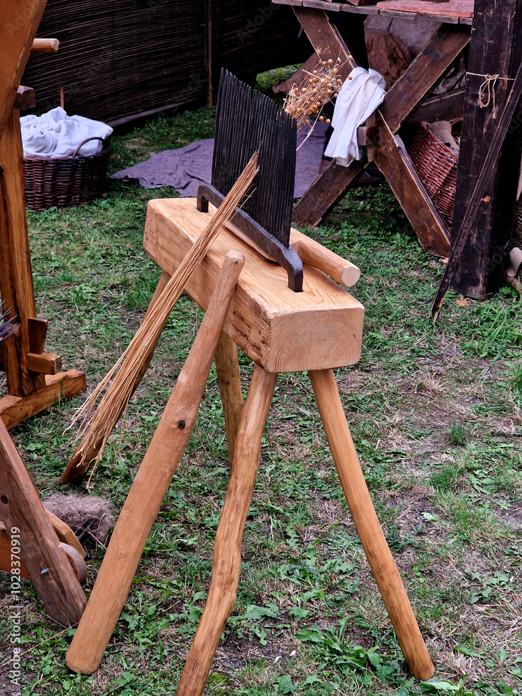 raking flax stalks over a comb, to create by breaking clean fibers for ...