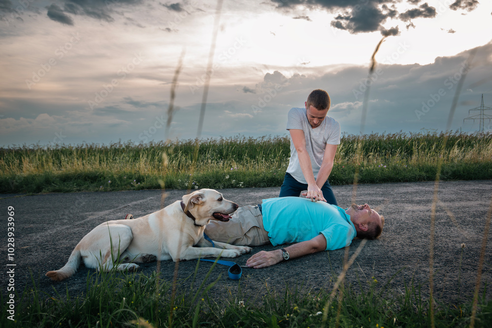 Dramatic resuscitation on rural road. Man provides first aid to ...