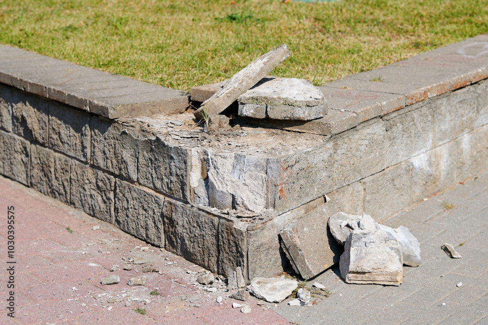 Crumbling concrete wall and broken bricks with debris scattered on the ...