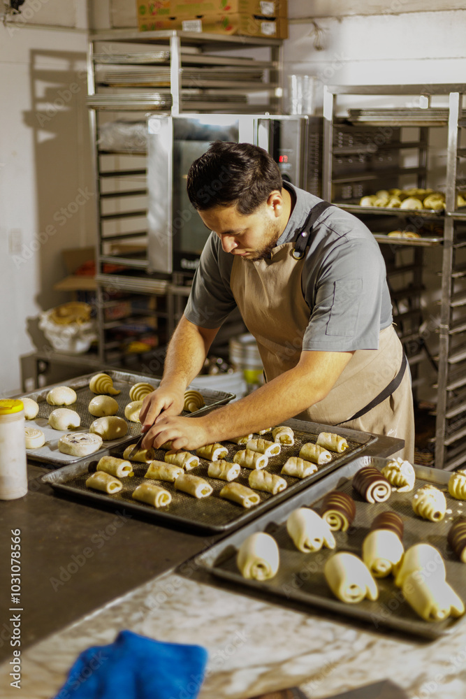 n the bakery, a focused Mexican baker carefully prepares pan dulce ...