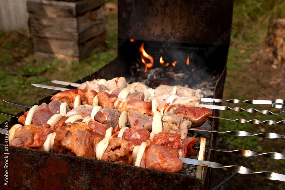 Juicy, appetizing barbecue on the grill. There are baked potatoes in ...