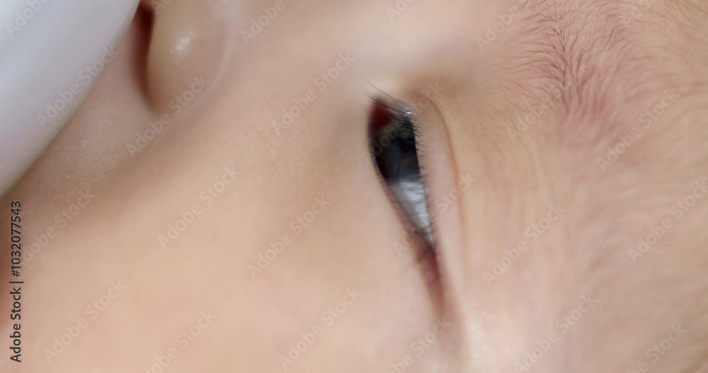 Capturing a baby girl’s focused gaze during bottle feeding in close-up ...