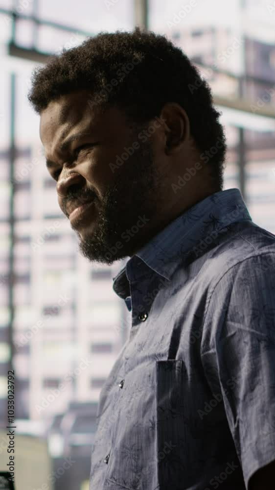 Vertical video Employee with grimace on face stretches to relieve ...