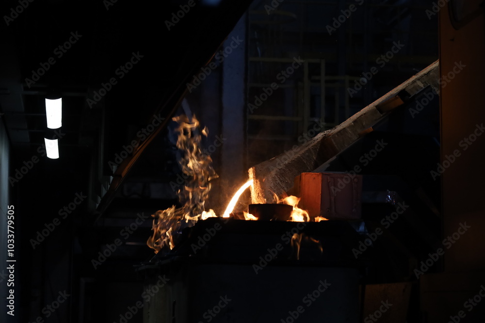 Molten metal pouring into containers in an industrial foundry. High ...