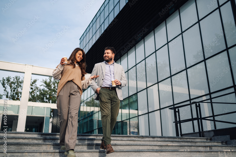 Business people walking and talking on stairs during coffee break ...