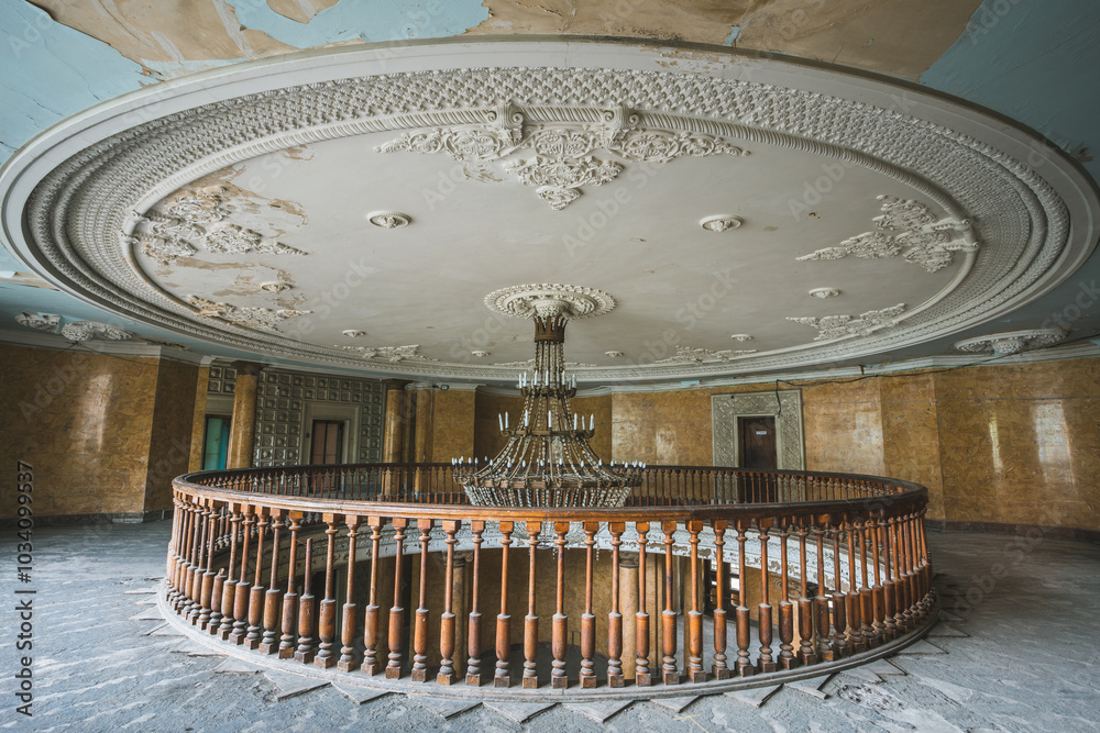 two-story hall in an abandoned hotel with a large chandelier and ...