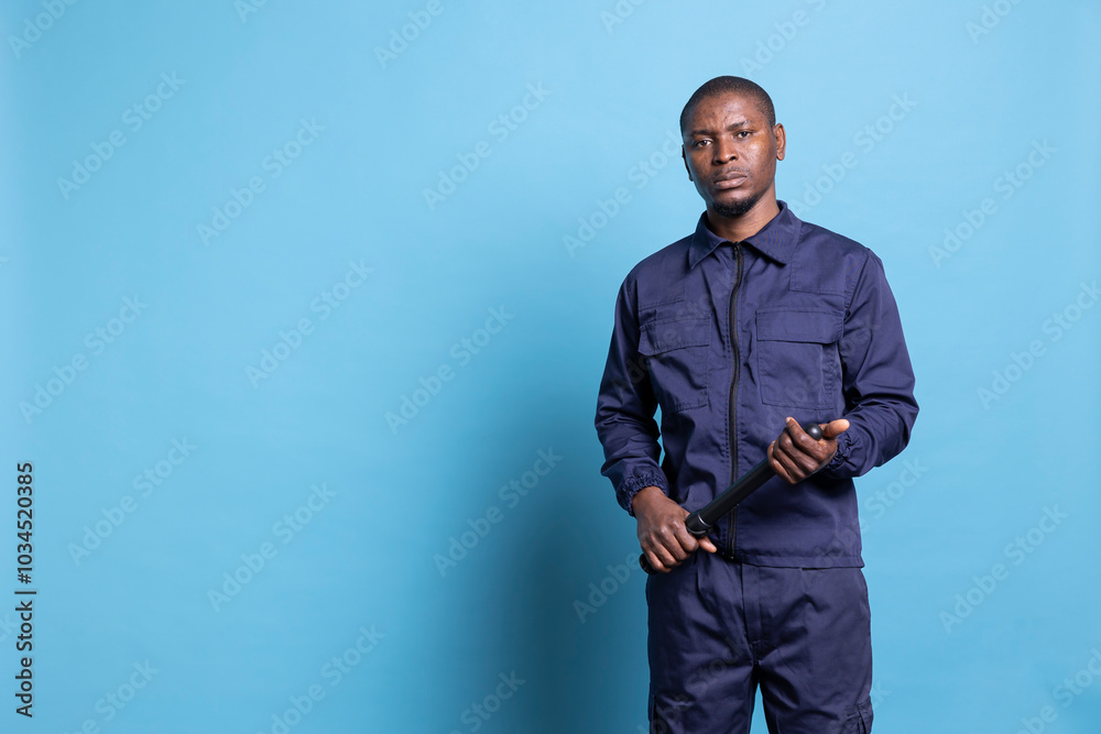 Security guard preparing his baton while on job duty in studio, working ...