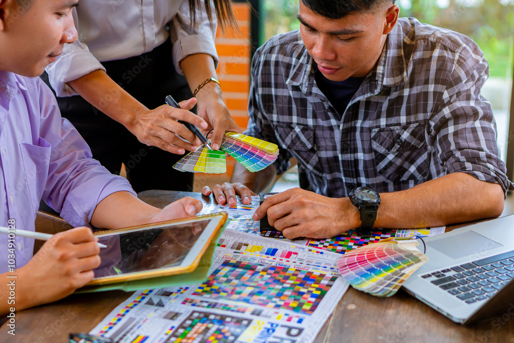 Team graphic designer checking print quality of media graphics proof ...