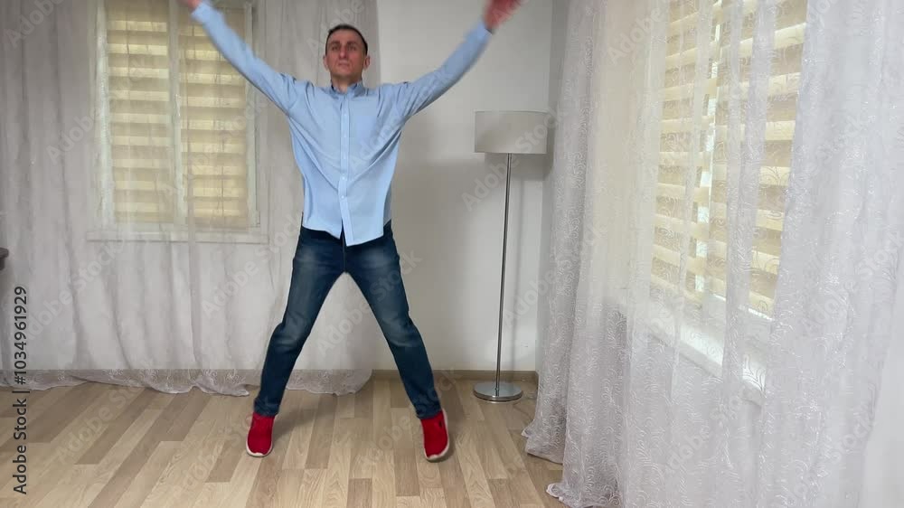 Man performing jumping jacks in a living room as part of a daily ...