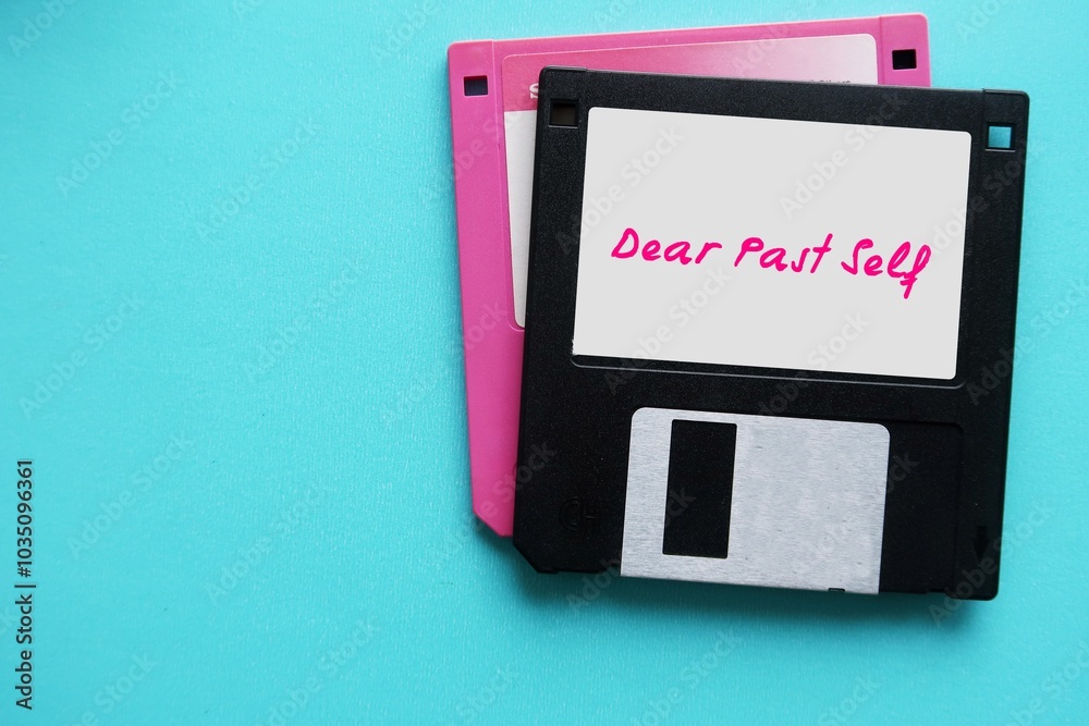 On blue copy space background, floppy disk with handwriting DEAR PAST ...
