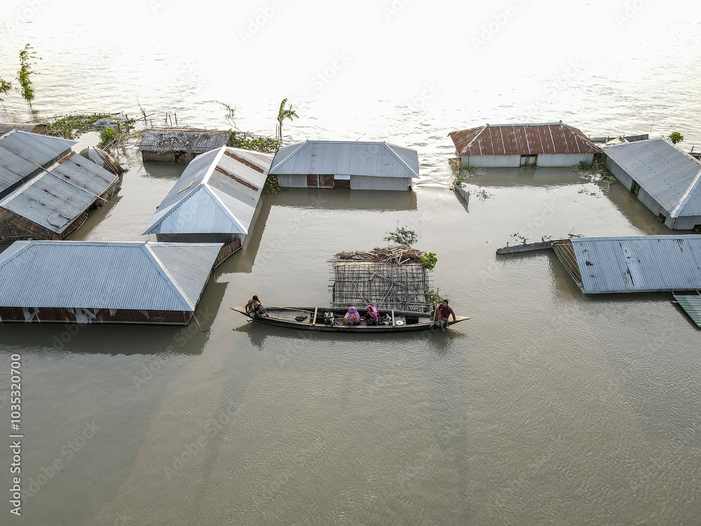 Aerial view of submerged homes and boats amidst flood water in a rural ...