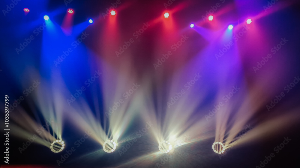 A vibrant stage illuminated by colorful spotlights casting beams of red ...