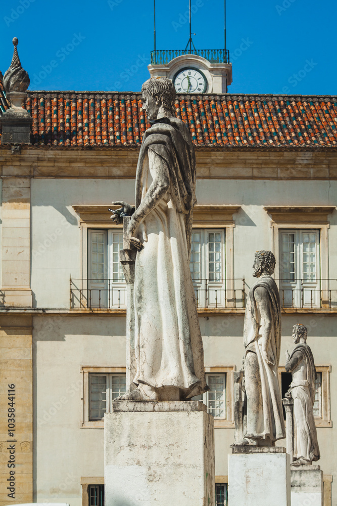 a group of classical statues from a side profile angle. The statues ...