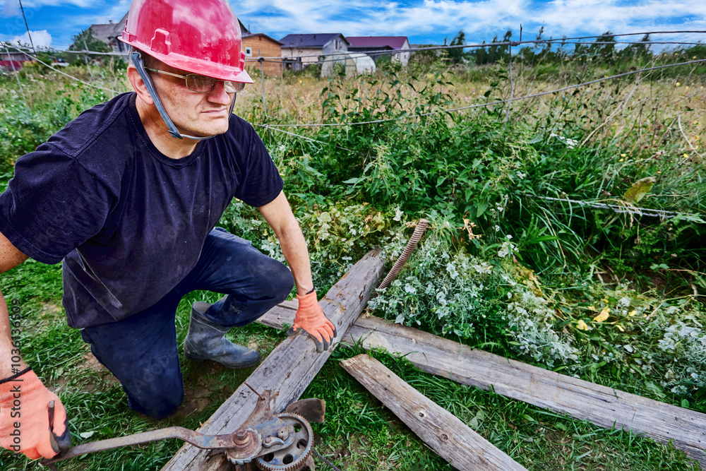 Rigging work on country site, using manual winch with gear mechanism ...