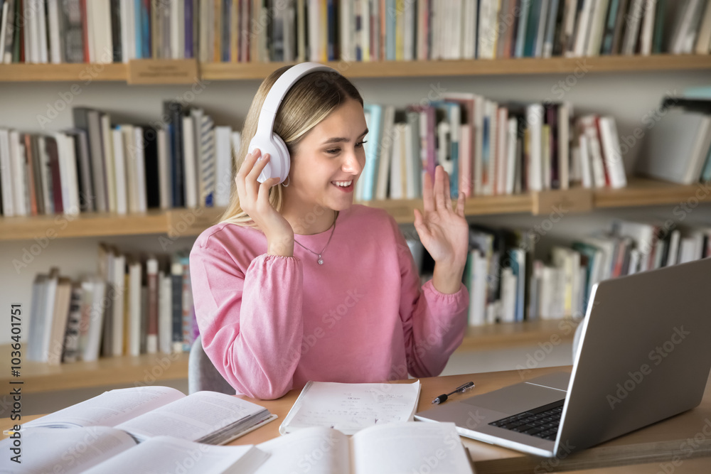 Happy smart young college student girl in wireless headphones waving ...