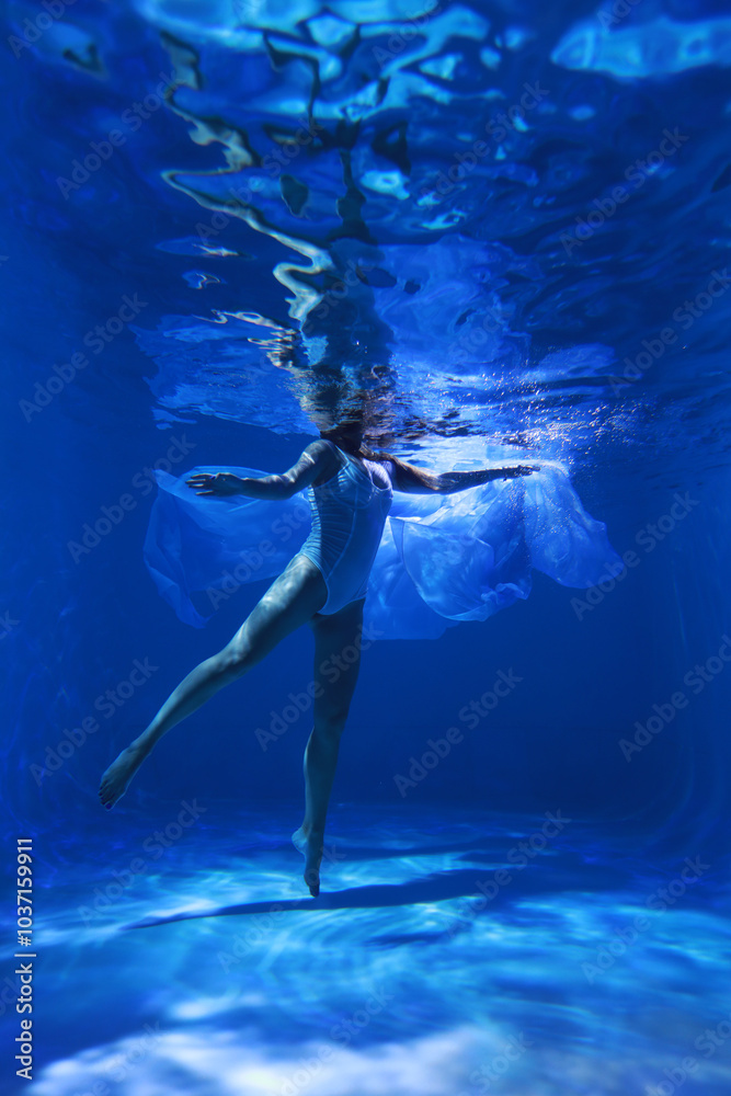 Woman in white bikini holding cloth and standing underwater in the ...