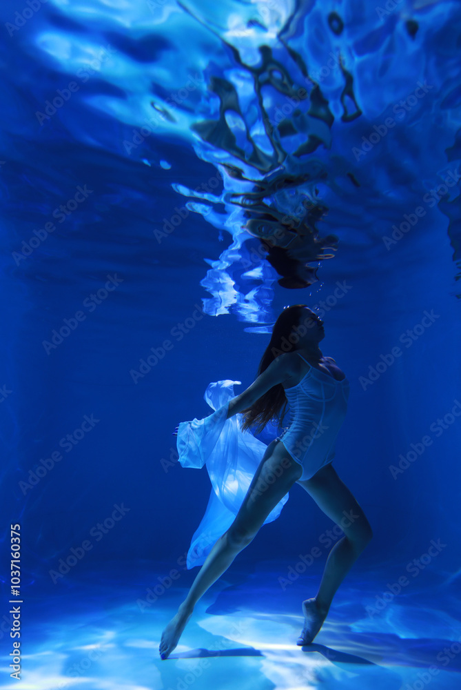 Woman in white bikini holding cloth and standing underwater in the ...