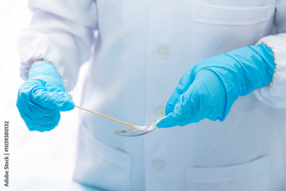 Scientist's hand holding a cotton swab and dipped in diluted rubbing ...