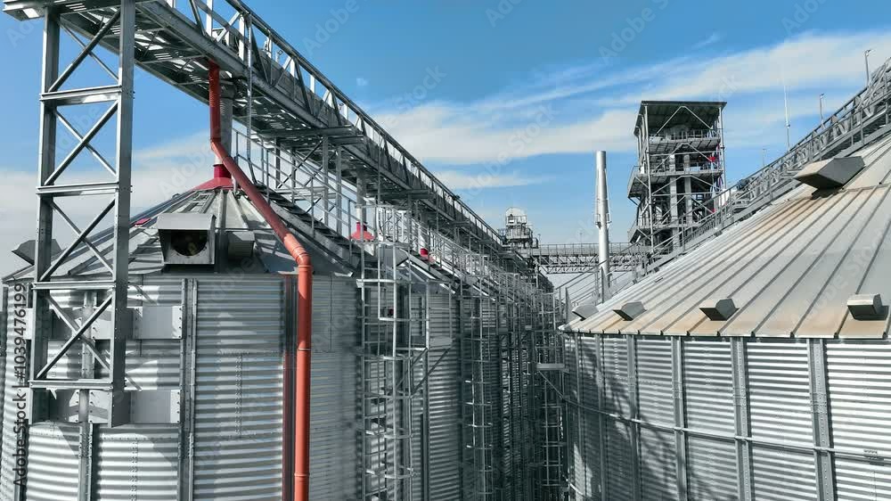 Grain storage facility with metal structures and blue sky. A modern ...