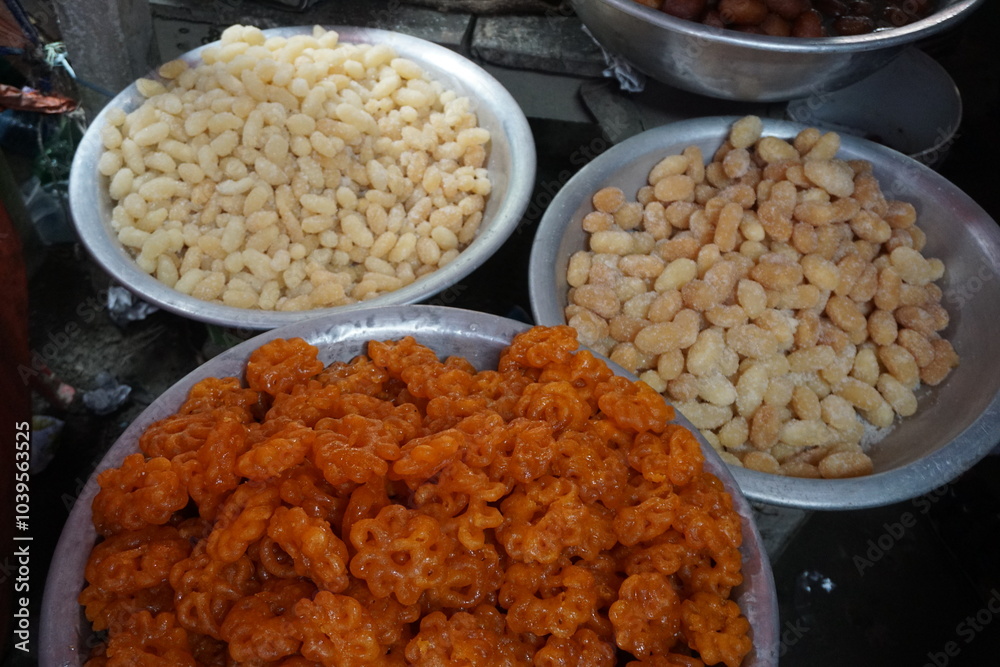 Freshly made sweet Jalebi or Imrati are served for sale in a sweet shop ...