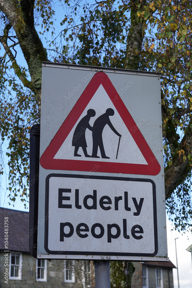 Elderly people crossing road sign in village. Pedestrians warning sign ...
