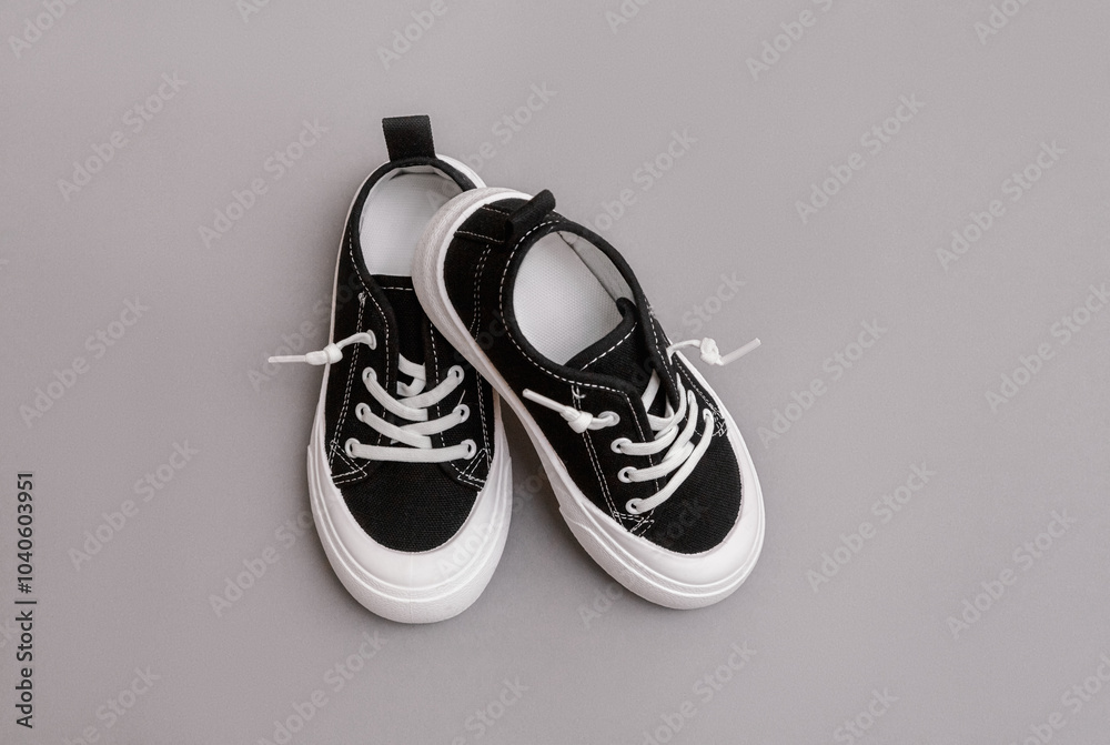 Child's black sneakers on the grey background. Fashion kids outfit ...