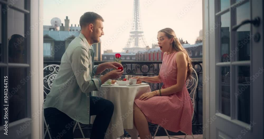 Romantic Proposal Unfolds on a Parisian Balcony as a Young Man Kneels ...