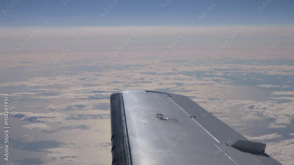aircraft wing turns banks cruising altitude high above clouds ...