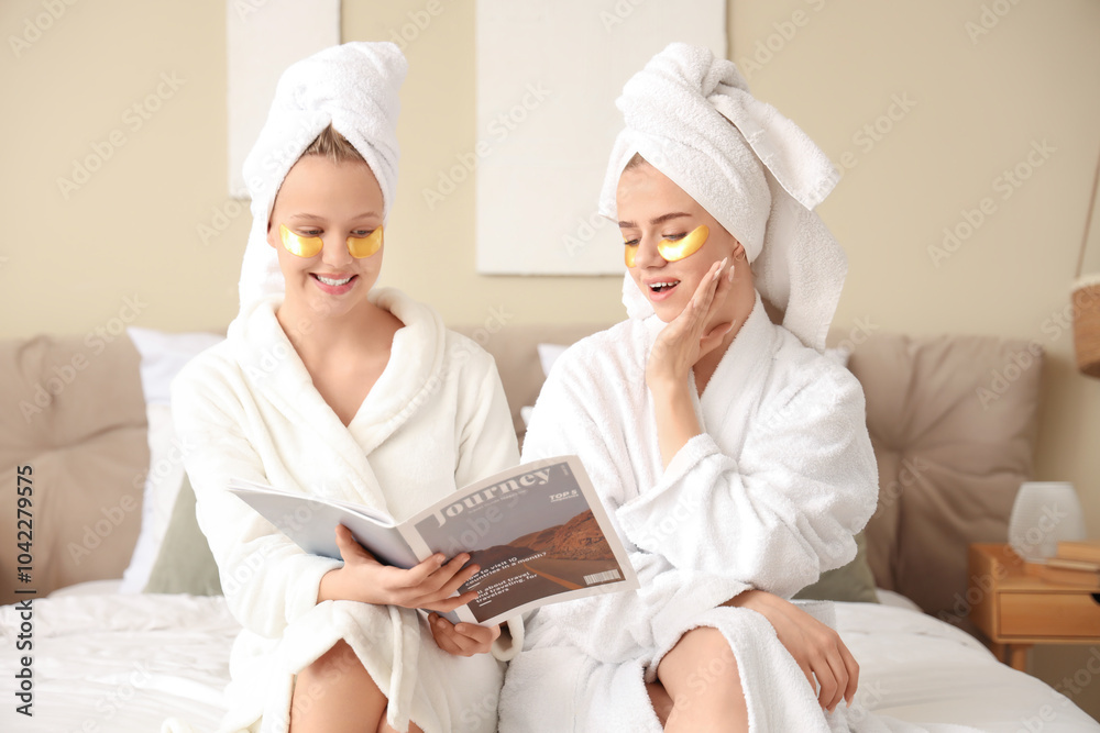 Beautiful young sisters after shower reading magazine in bedroom Stock ...
