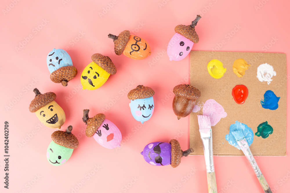 Colorful hand painted acorns with various facial expressions lined up ...
