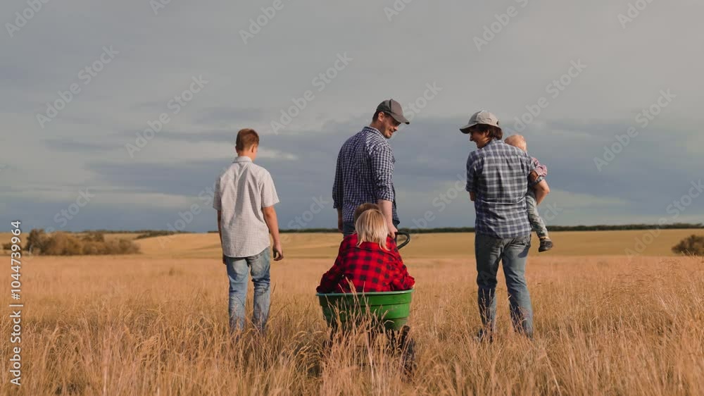 Happy farmer family with children play in country field backside view ...