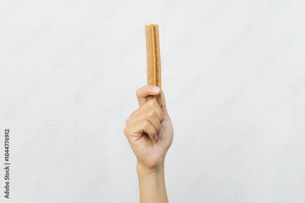 a picture of dog chew holding by hand on isolated white background ...