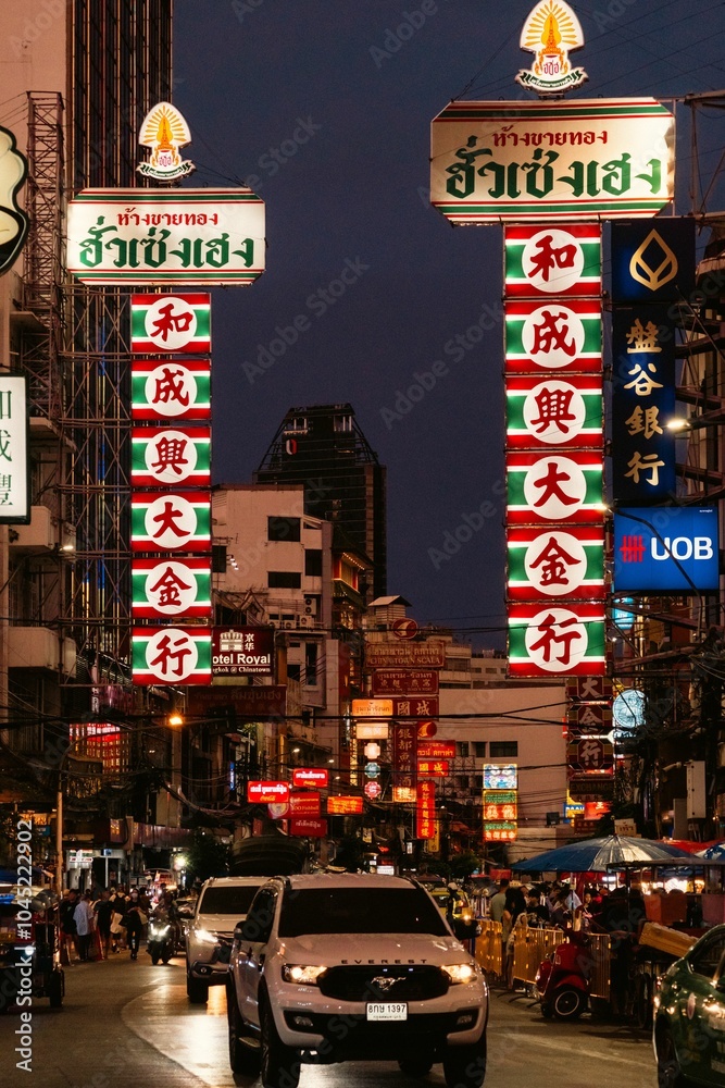 Yaowarat Road in Bangkok's Chinatown, capturing the vibrant neon signs, bustling traffic, and ...