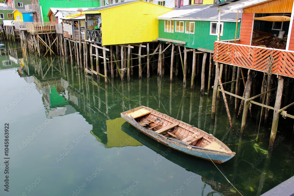 bote pequeño junto a casas-palafito, construcciones sobre pilares en el ...