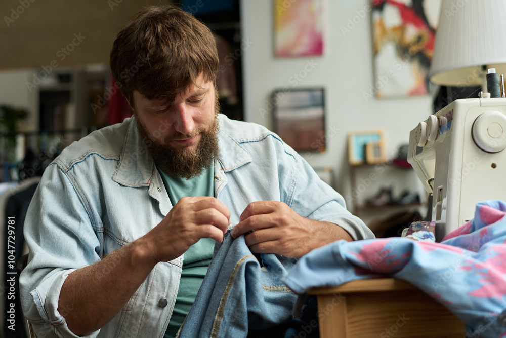 Bearded male worker or owner of thrift shop upcycling secondhand denim ...