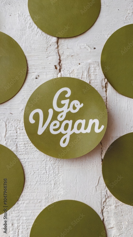 Bold "Go Vegan" sticker on a rustic white wood background promotes ...