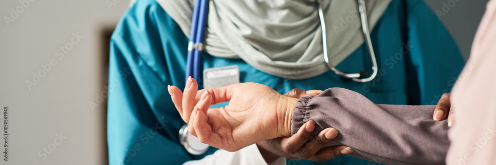 Muslim nurse in scrubs feeling patient pulse during routine checkup ...