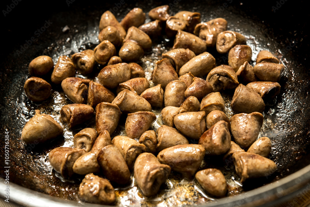 Fried chicken hearts in butter, cooked to golden perfection in a pan ...