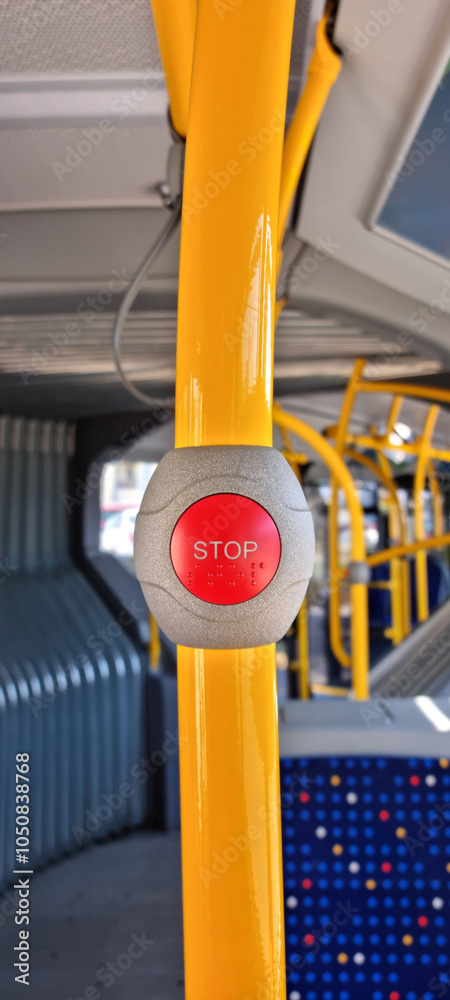 An accessible red emergency stop button in a bus with Braille markings ...