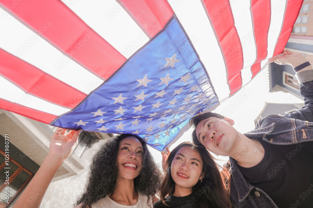 Three friends smile joyfully under an American flag, symbolizing unity ...